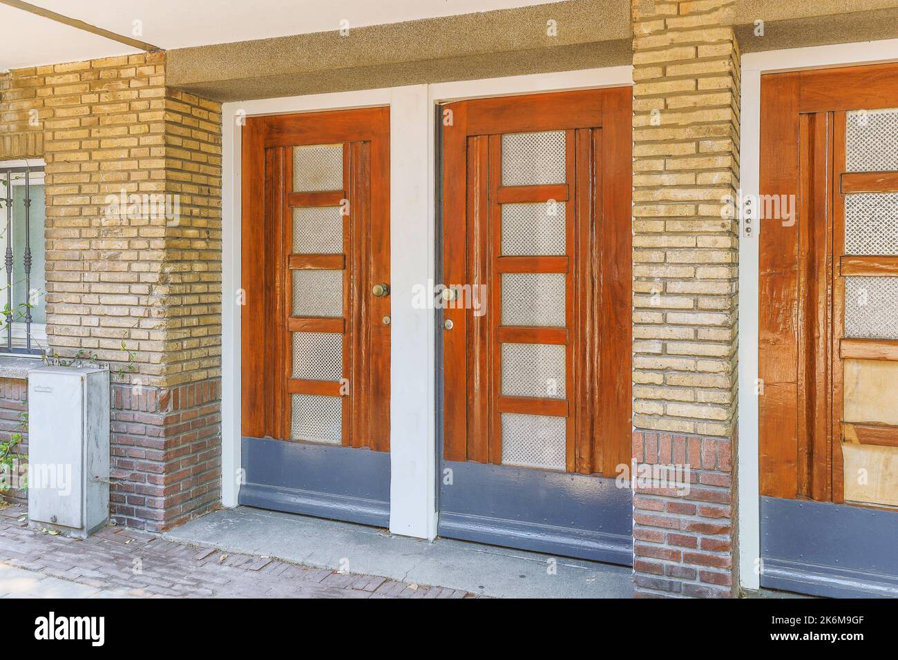 The front view of a brick building with signs, pavement and wooden ...