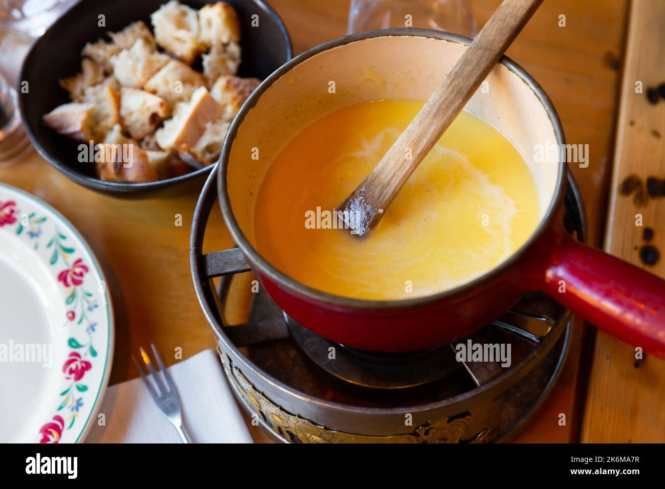 French variation of fondue, Fondue Savoyarde, preparing on table Stock ...