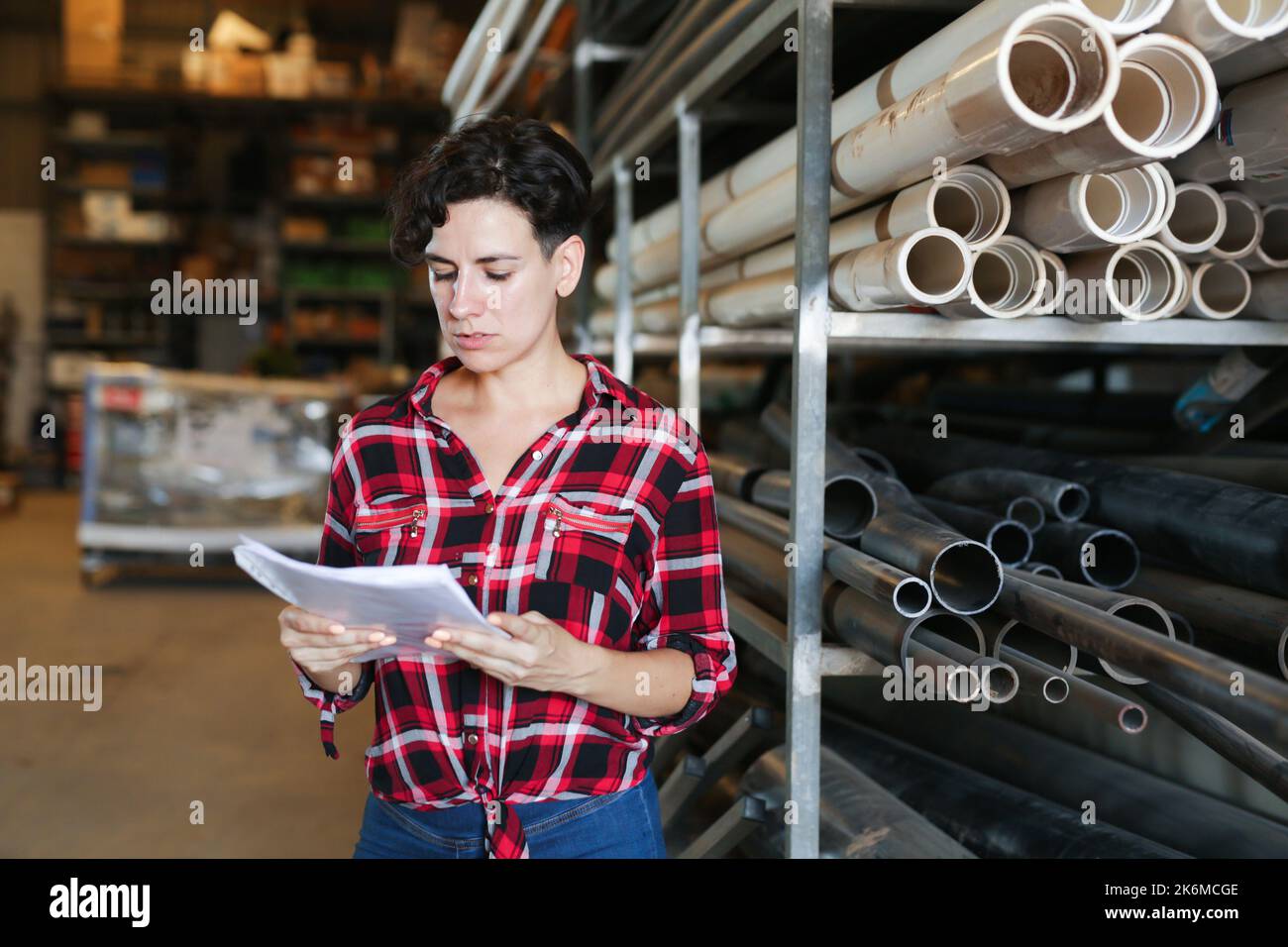Woman inspecting warehouse to check quantity of goods on shelves Stock ...