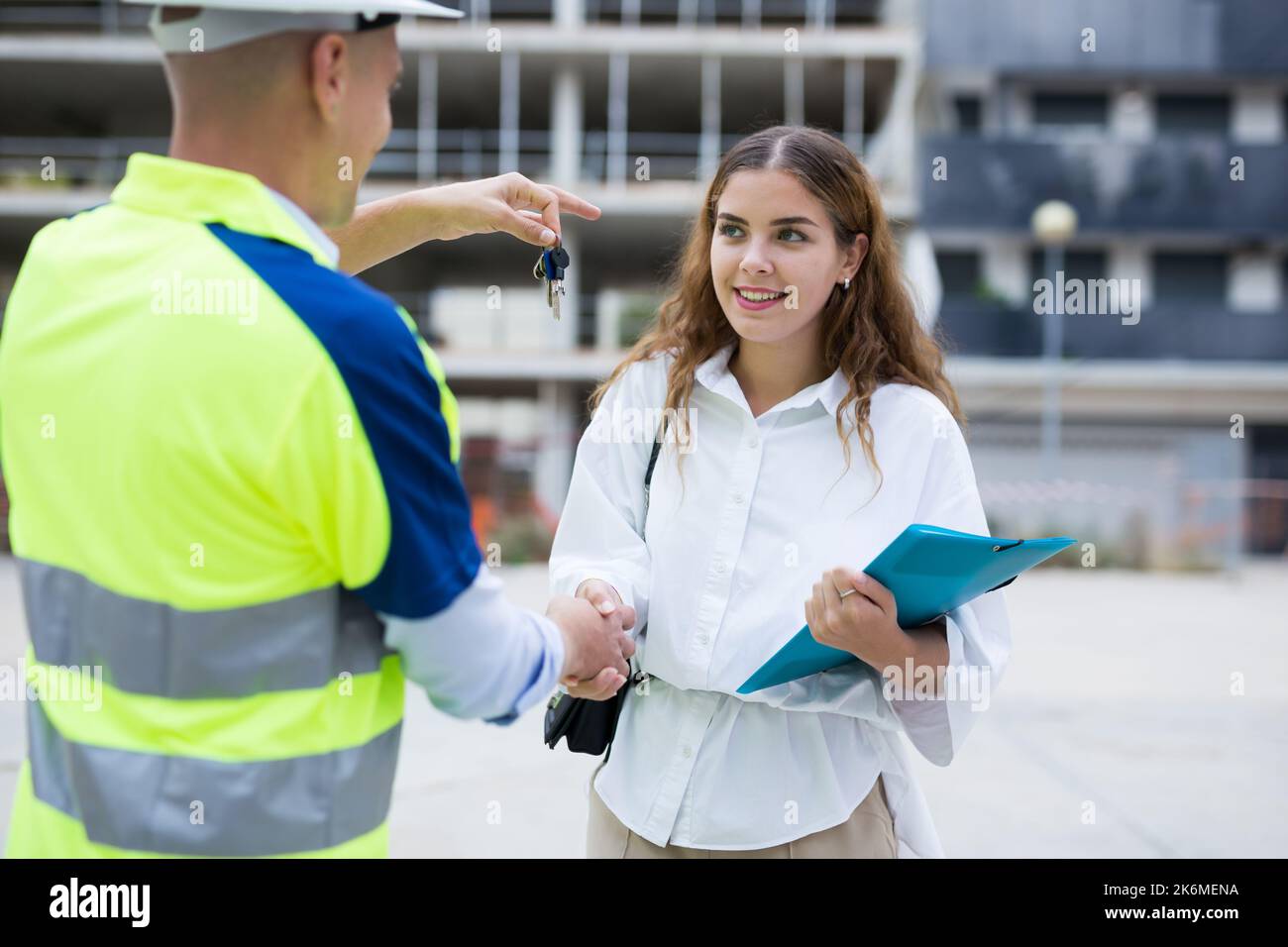 Smiling man contractor gives a young female customer the keys Stock ...