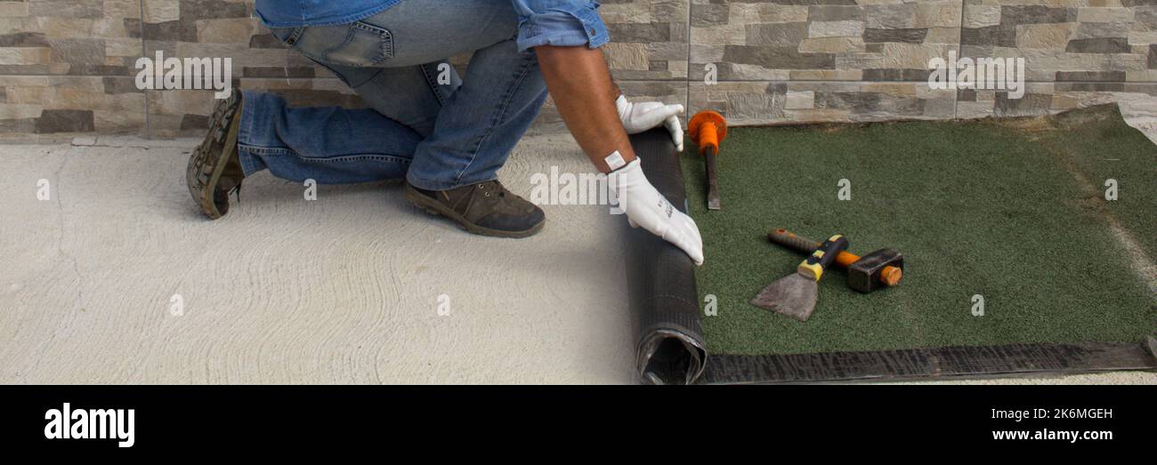 Construction worker at work while unrolling the tarred bituminous ...