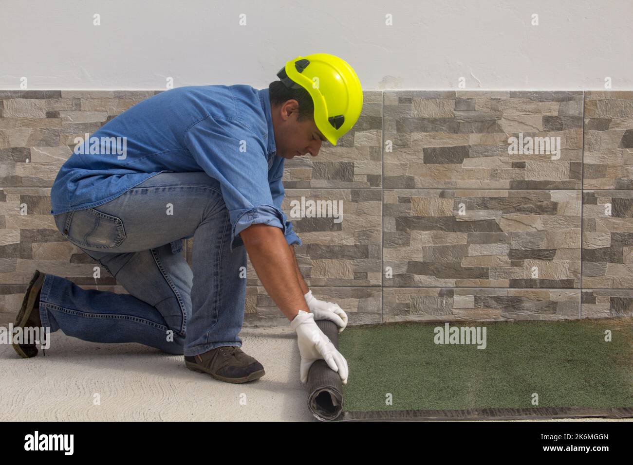 Construction worker at work while unrolling the tarred bituminous ...