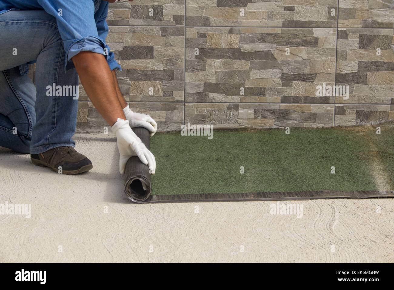 Construction worker unrolling the tarred bituminous sheath for the ...
