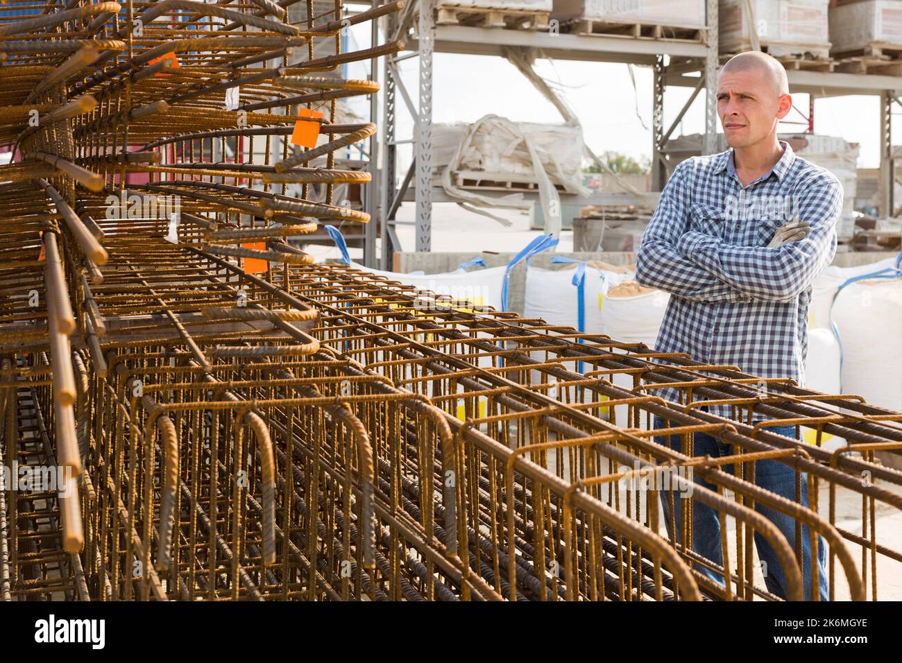 Construction shop worker prepares metal rebar for loading onto truck ...