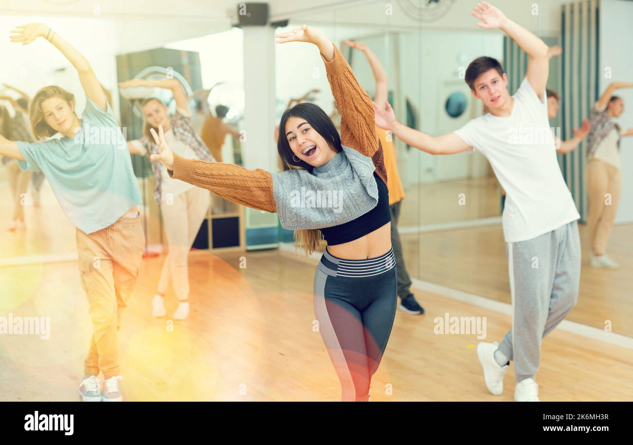 Expressive hispanic teenage girl practicing energetic dance movements ...