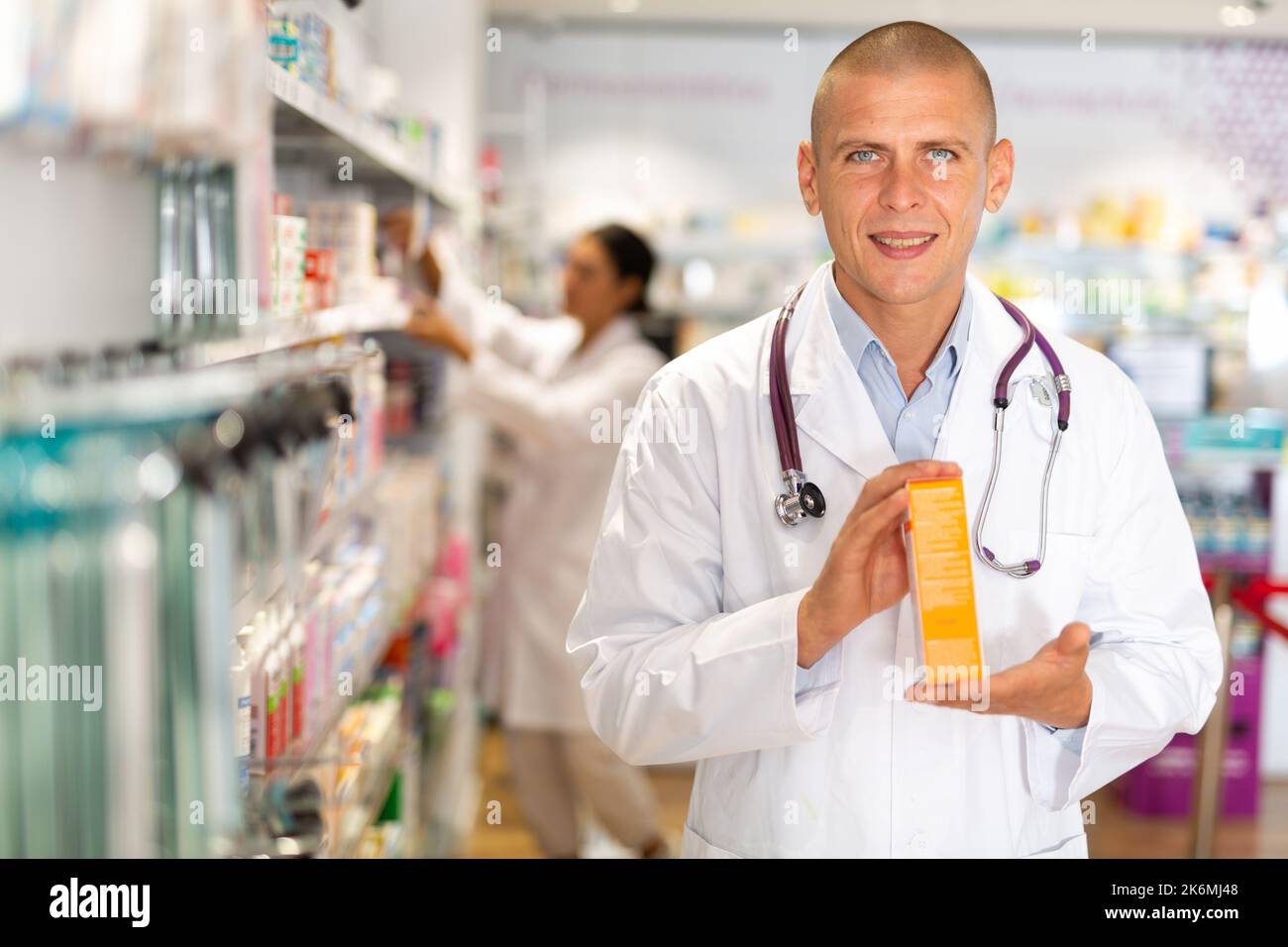 Male pharmacist offers medicine while standing in the trading floor of ...
