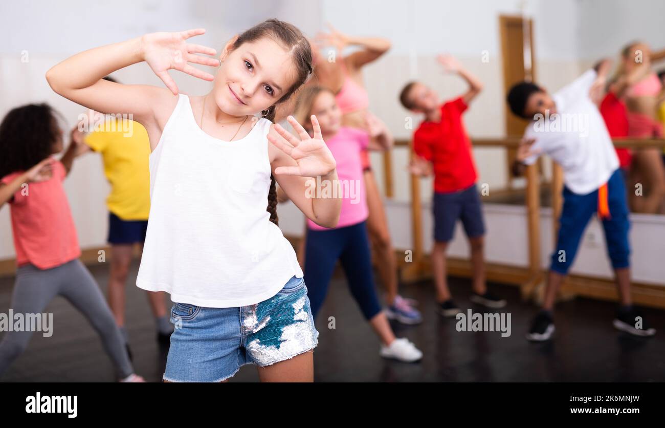 Tween girl training vigorous dance during group class Stock Photo - Alamy