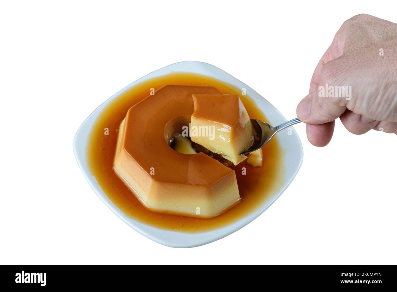 Man taking a slice with a spoon of condensed milk pudding with caramel ...
