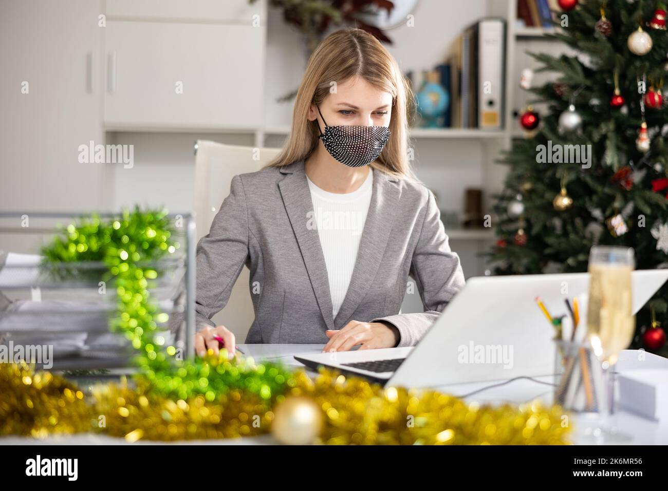 Woman in mask working during New Year Stock Photo - Alamy