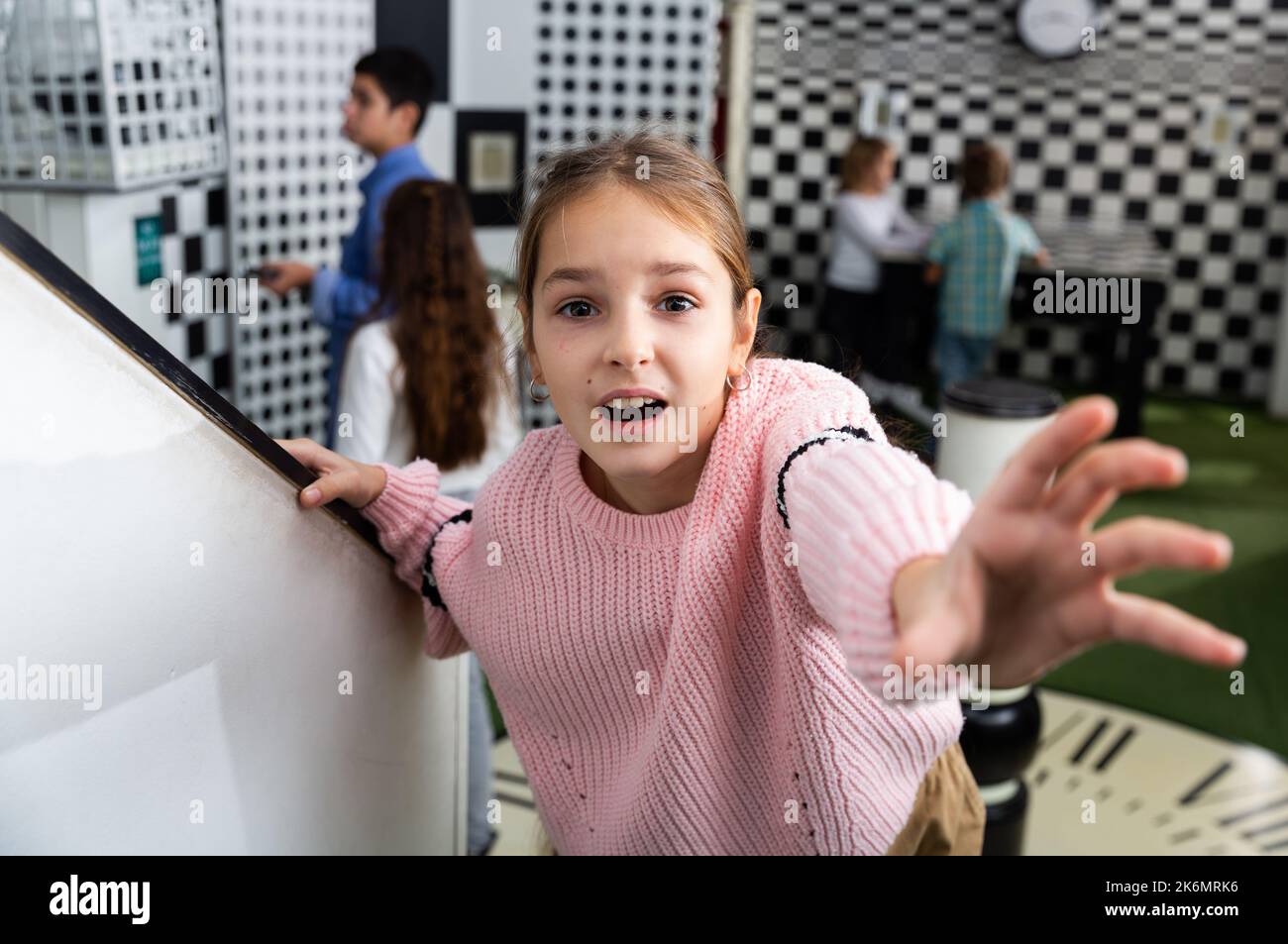 Tween girl holding out hand to reach out something in quest room Stock ...