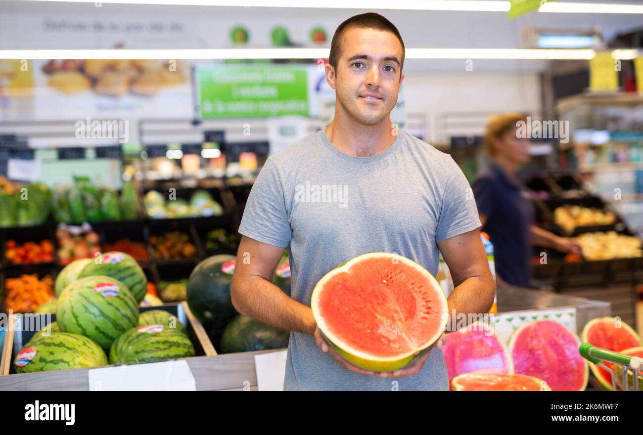 Male shopper holding watermelon in supermarket grocery section Stock ...