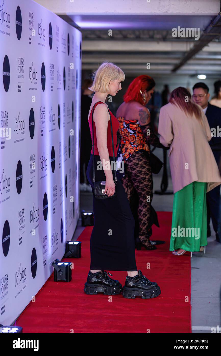A guest poses on the red carpet at the Justin Cassin fashion show ...