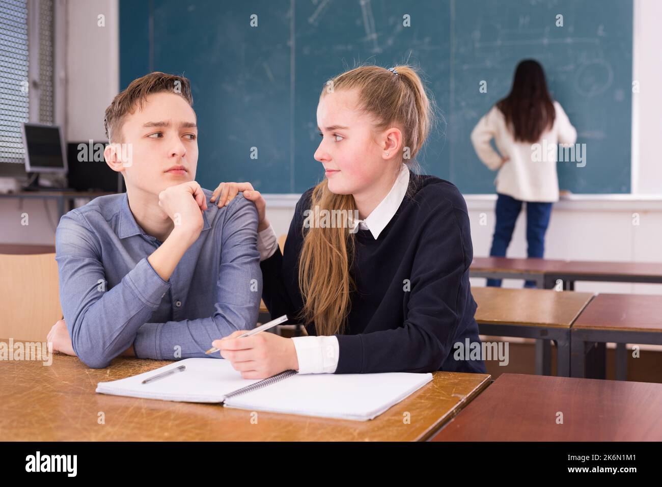 Thoughtful young students during writing notes in classroom Stock Photo ...