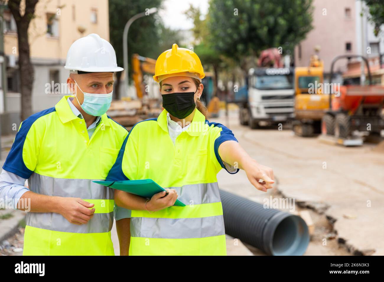 Civil engineers in masks checking work process Stock Photo - Alamy