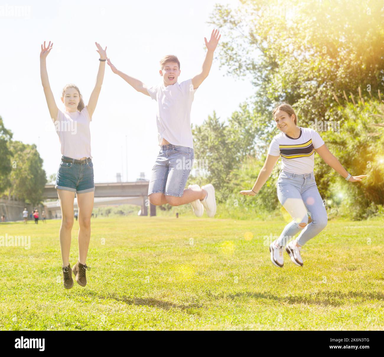 Happy teenagers jumping on the green lawn Stock Photo - Alamy