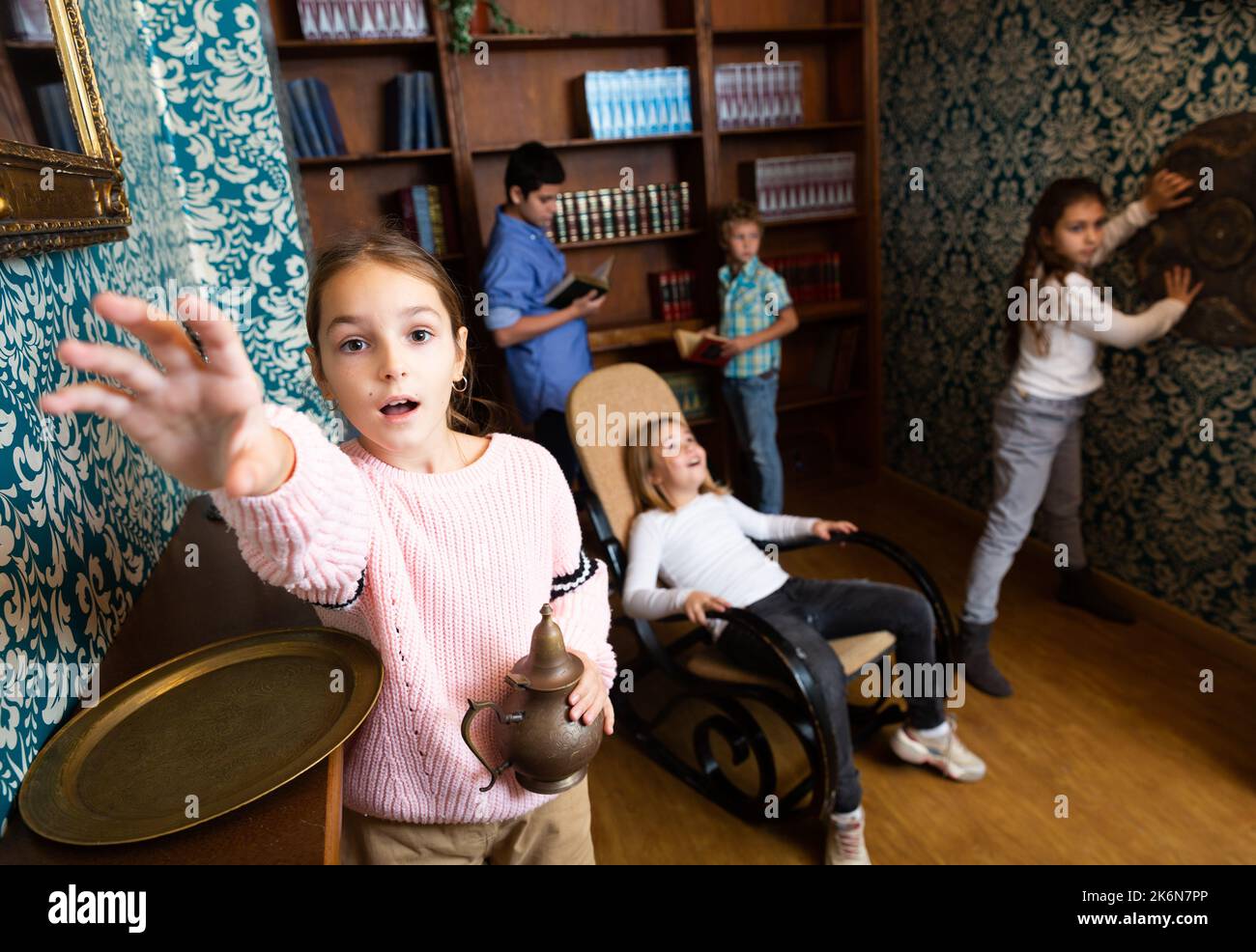 Tween girl trying to reach for something in escape room Stock Photo - Alamy