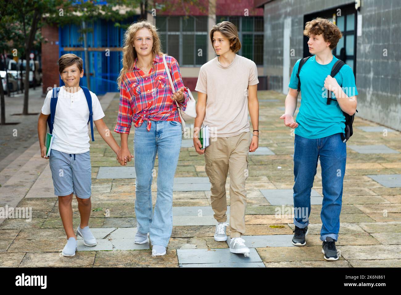 Group of four teens going home from school Stock Photo - Alamy