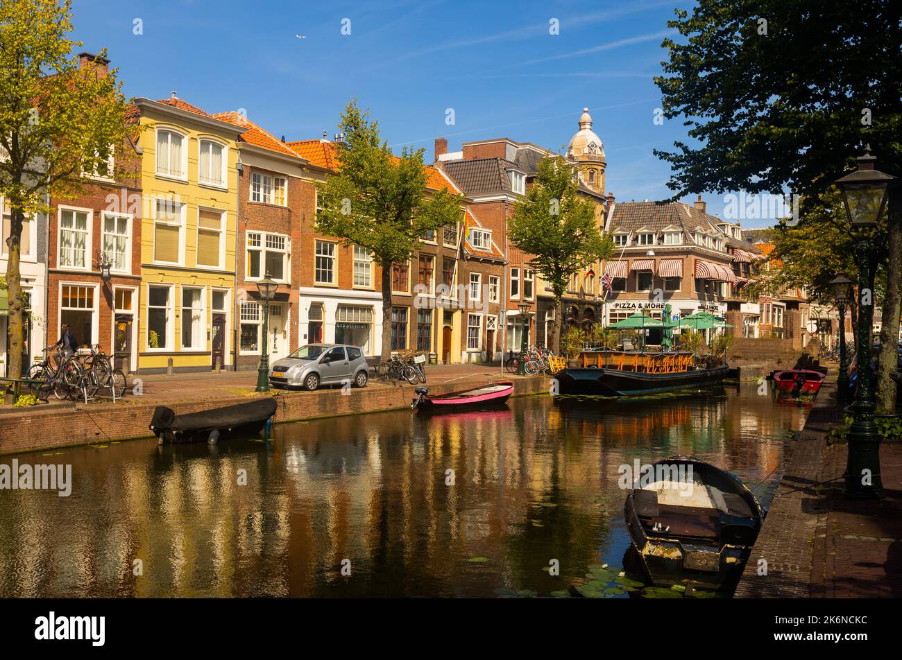 Scenic cityscape of Leiden with townhouses and embankments along canal ...