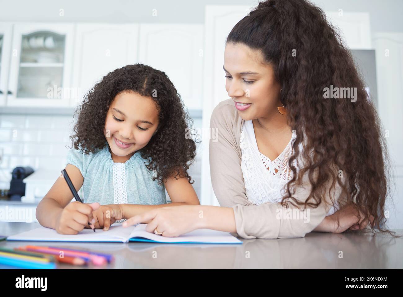 Shes focused and happy, well done mom. a mother helping her daughter ...