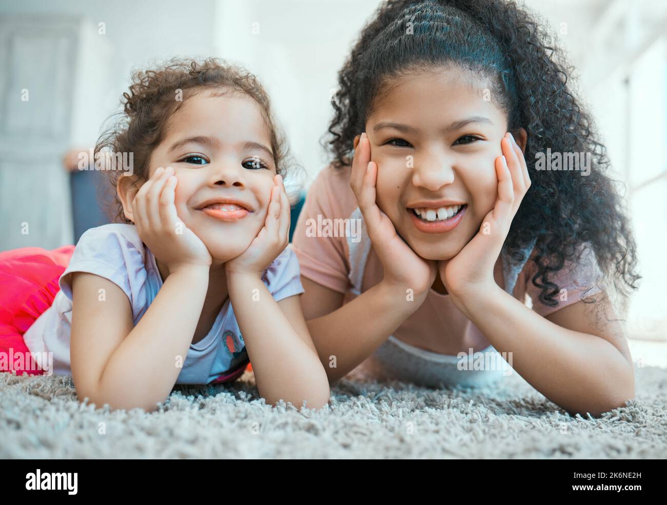 They are pink in a world of blue. two sisters bonding at home Stock ...