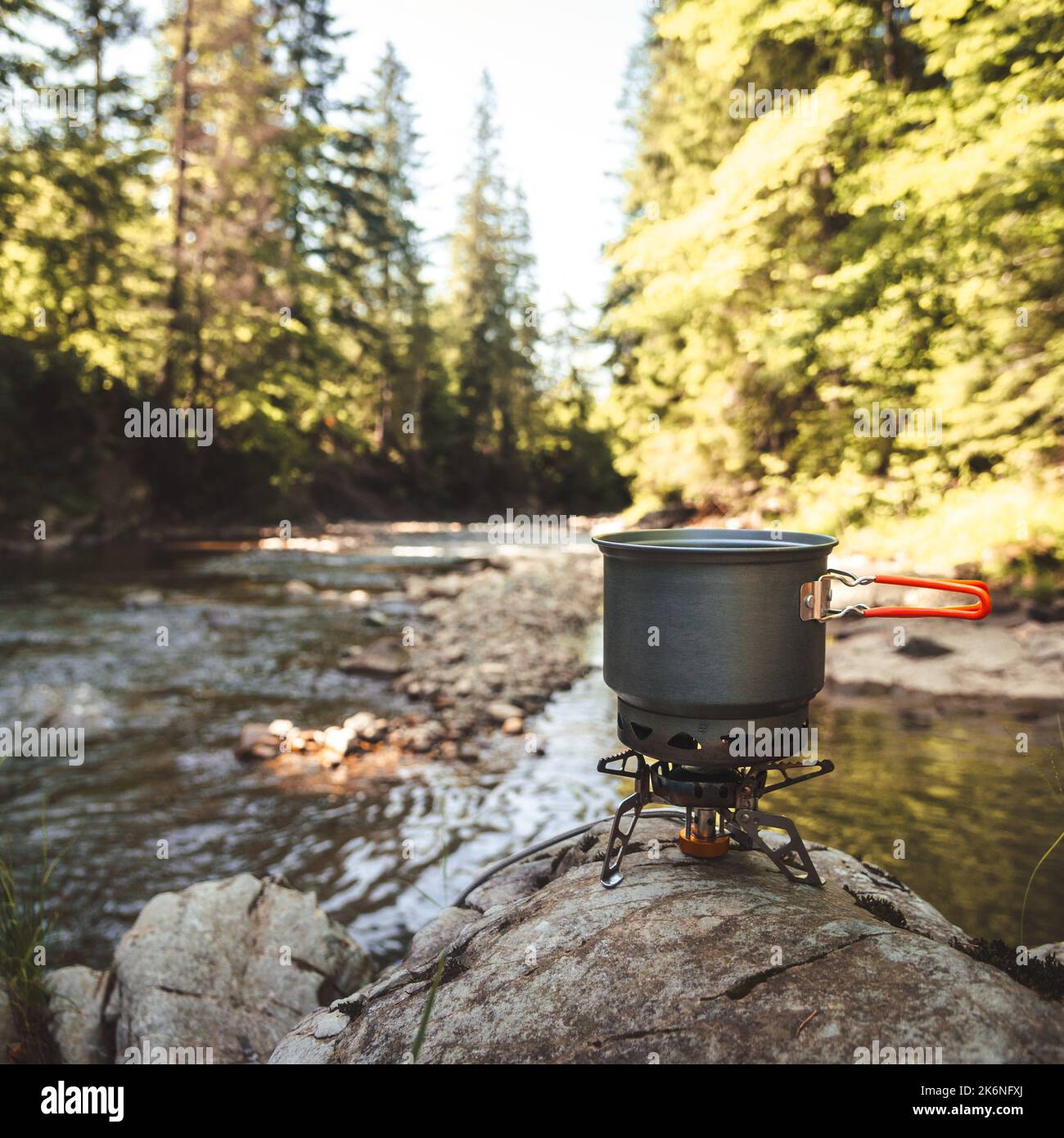 Cooking food using camping gas during the hike Stock Photo - Alamy