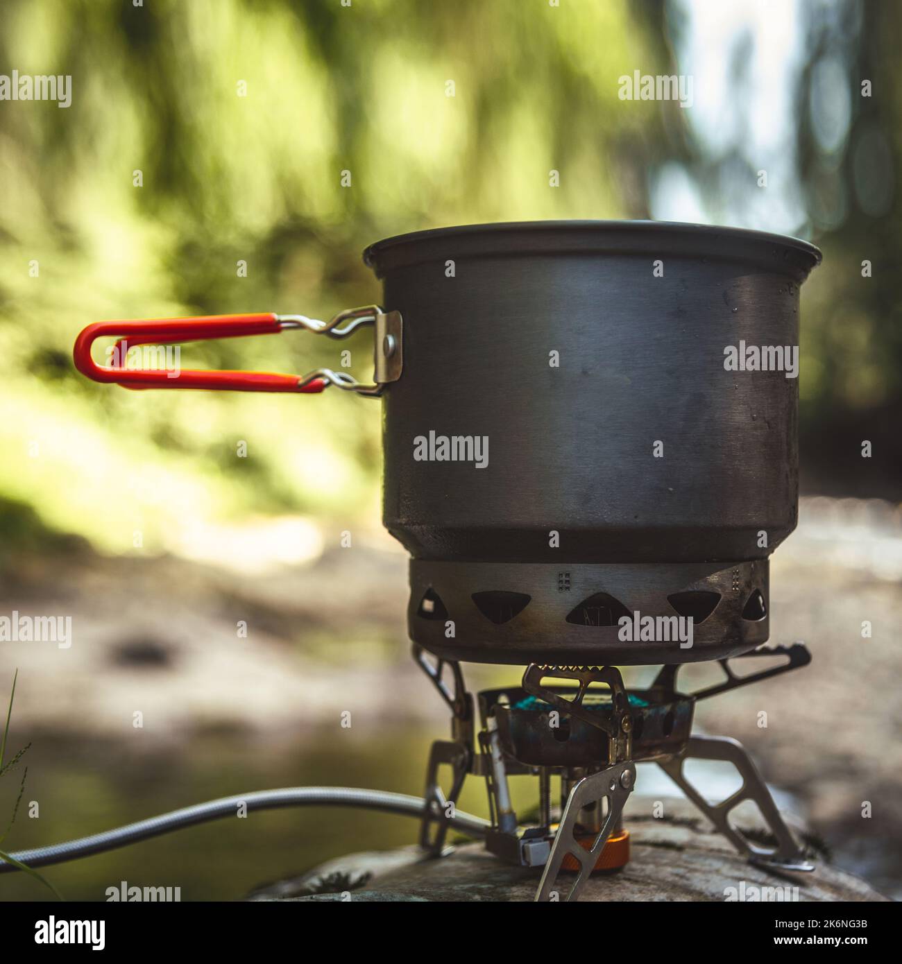 Cooking food using camping gas during the hike Stock Photo - Alamy