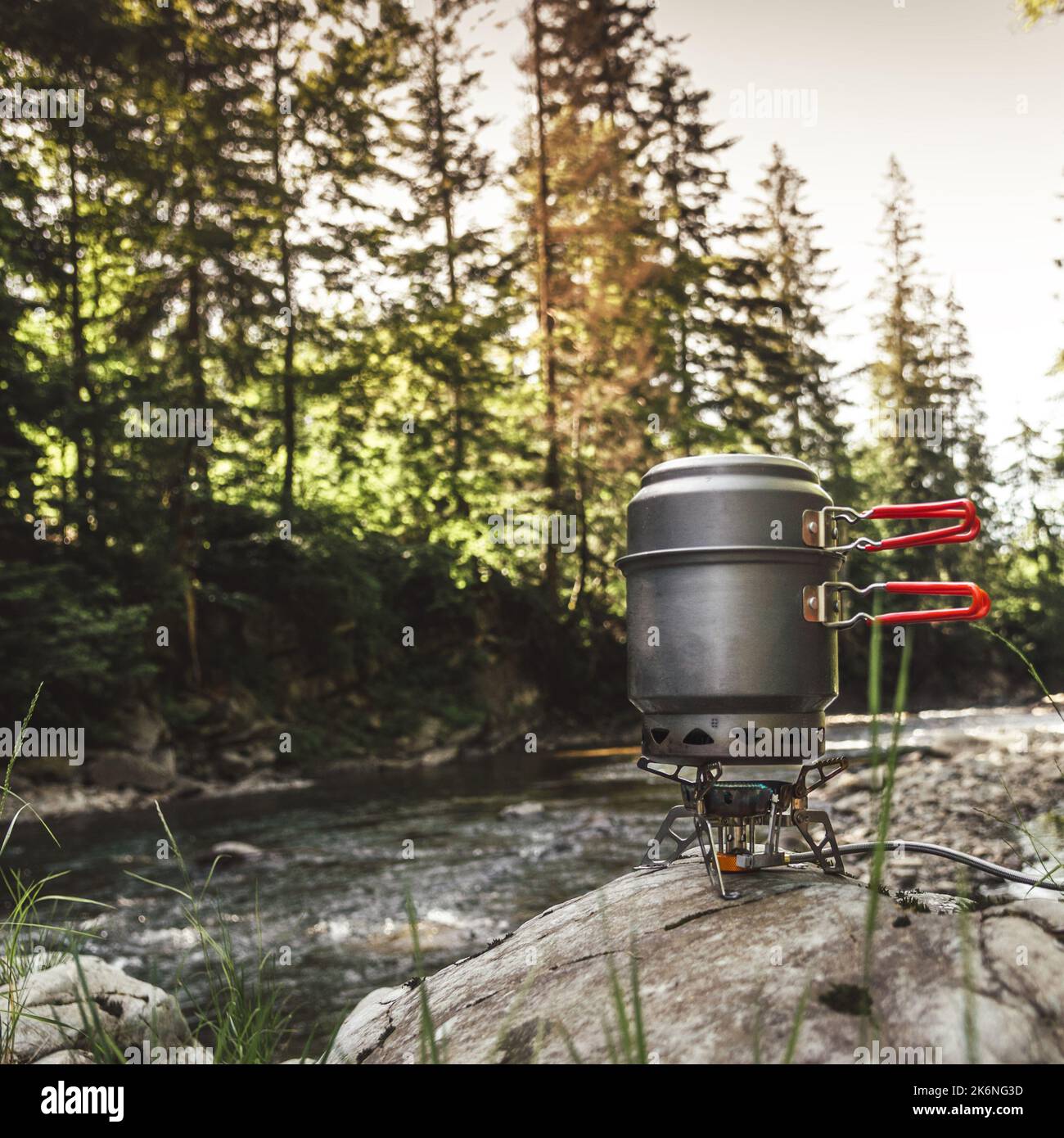 Cooking food using camping gas during the hike Stock Photo - Alamy