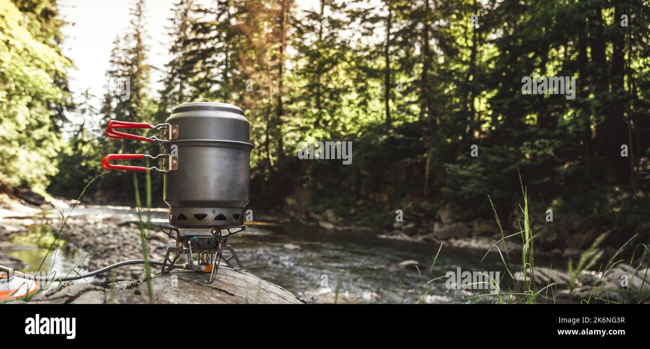 Cooking food using camping gas during the hike Stock Photo - Alamy