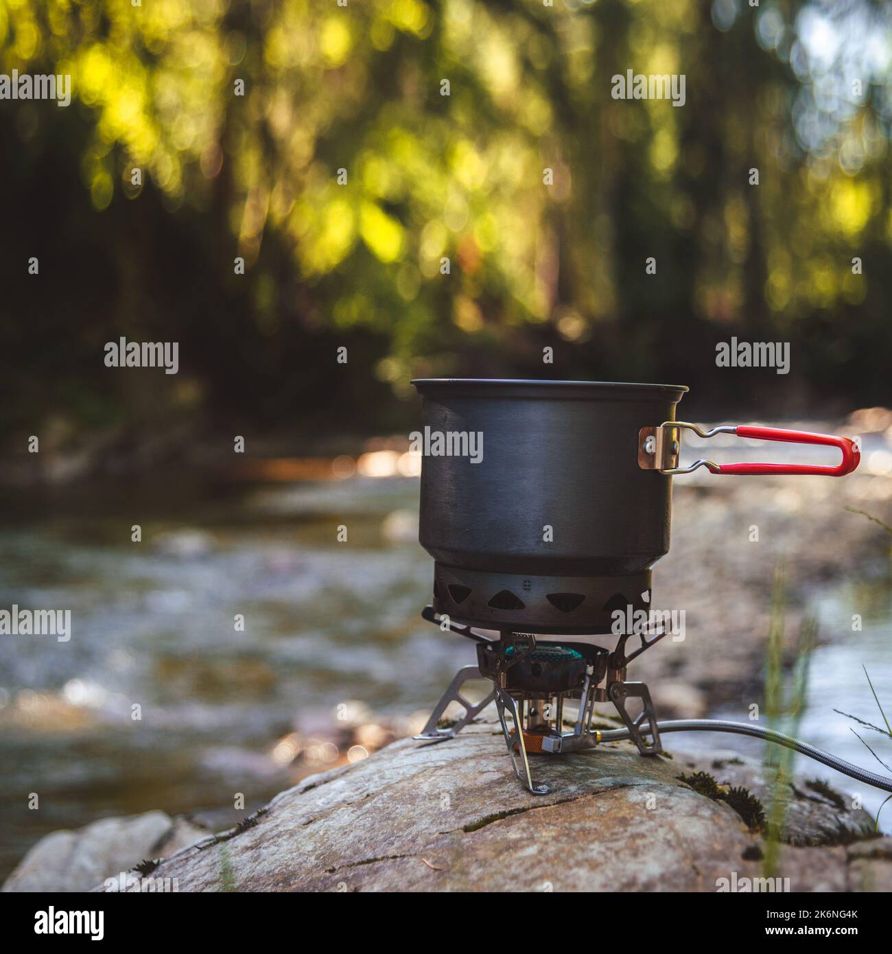 Cooking food using camping gas during the hike Stock Photo - Alamy