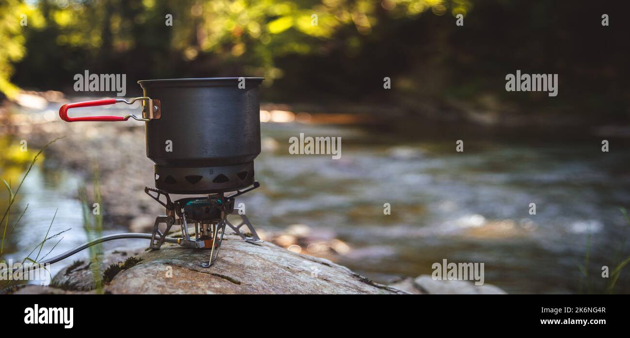 Cooking food using camping gas during the hike Stock Photo - Alamy