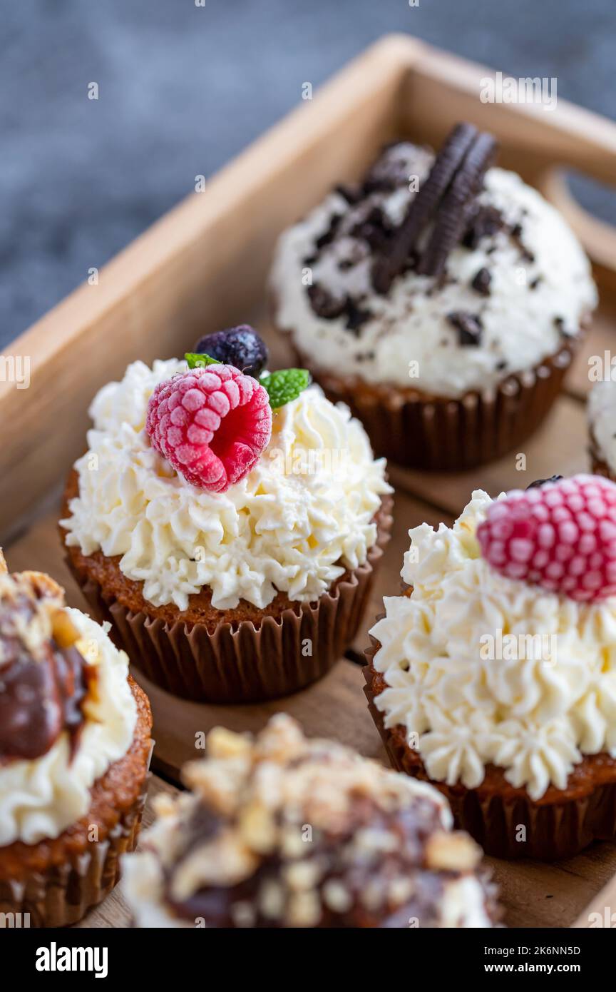 Tasty sweet muffins with mascarpone creme and chocolate, raspberry and ...
