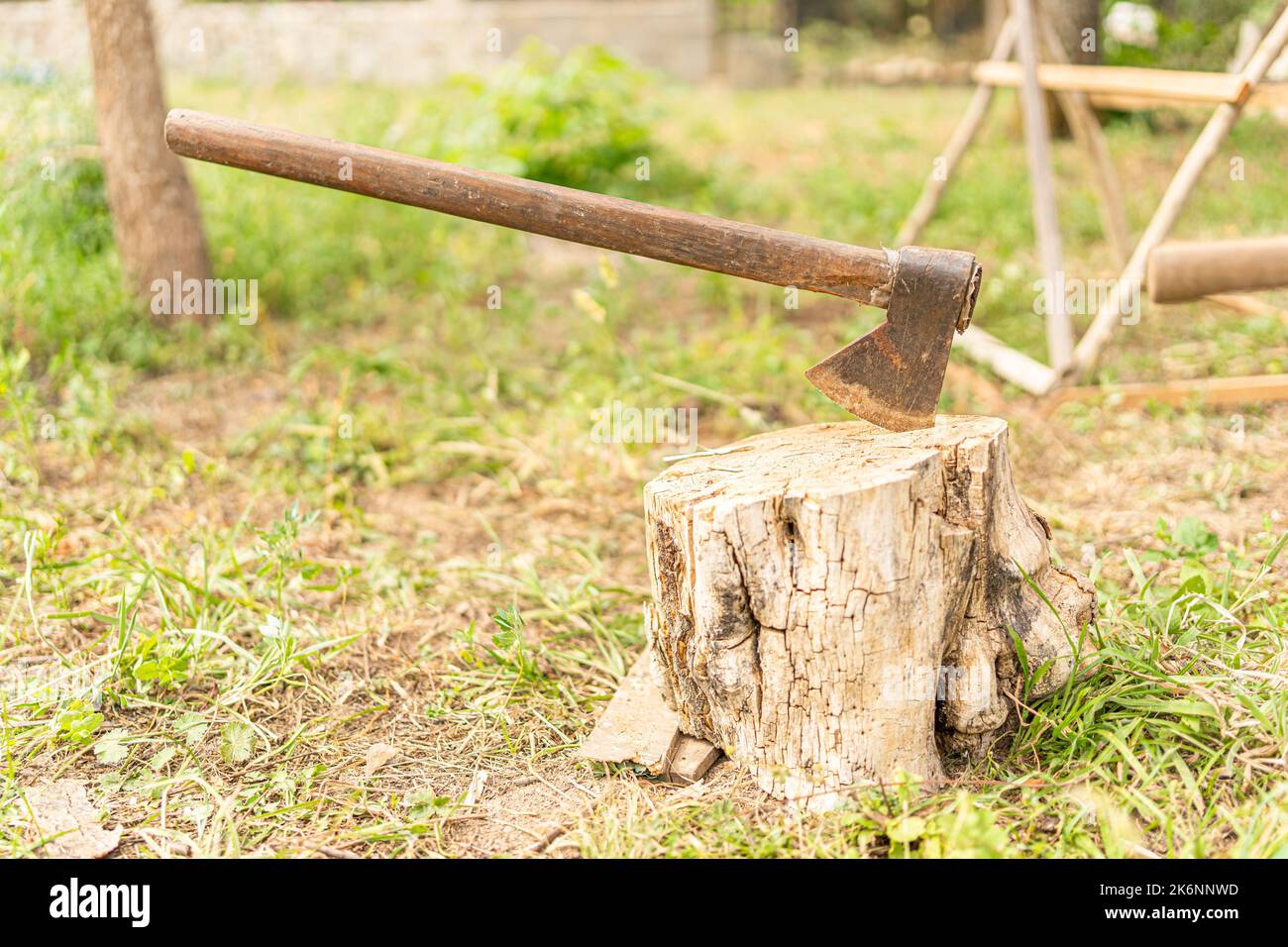 Rusty axe nailed to a log in the garden Stock Photo - Alamy