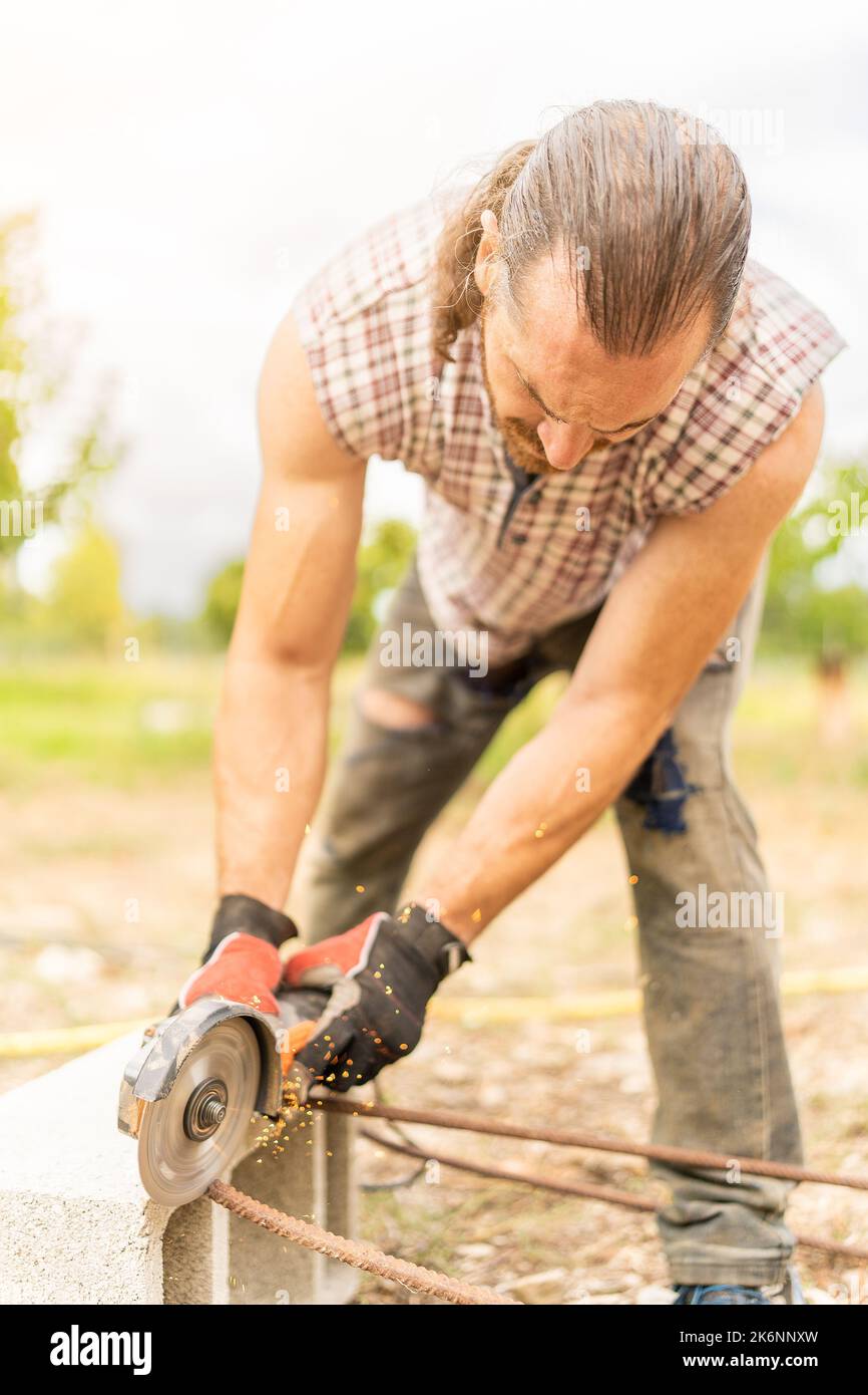 Man cutting iron using a radial saw Stock Photo - Alamy
