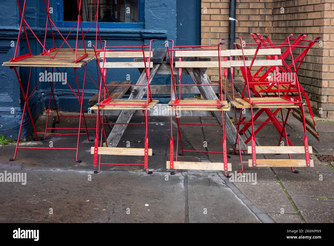 Red stacked chairs outside a restaurant Stock Photo - Alamy