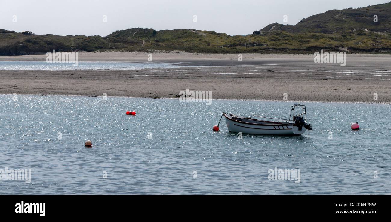 A boat moored in shallow water. Sandy beach. Seascape. White boat on ...
