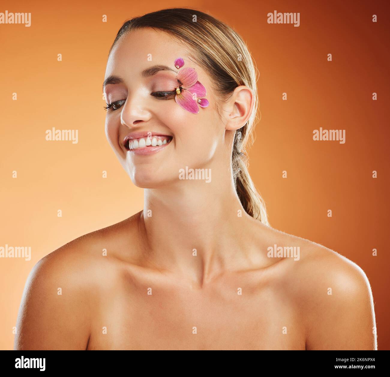 Flower, face and woman with smile for skincare against a brown mockup ...