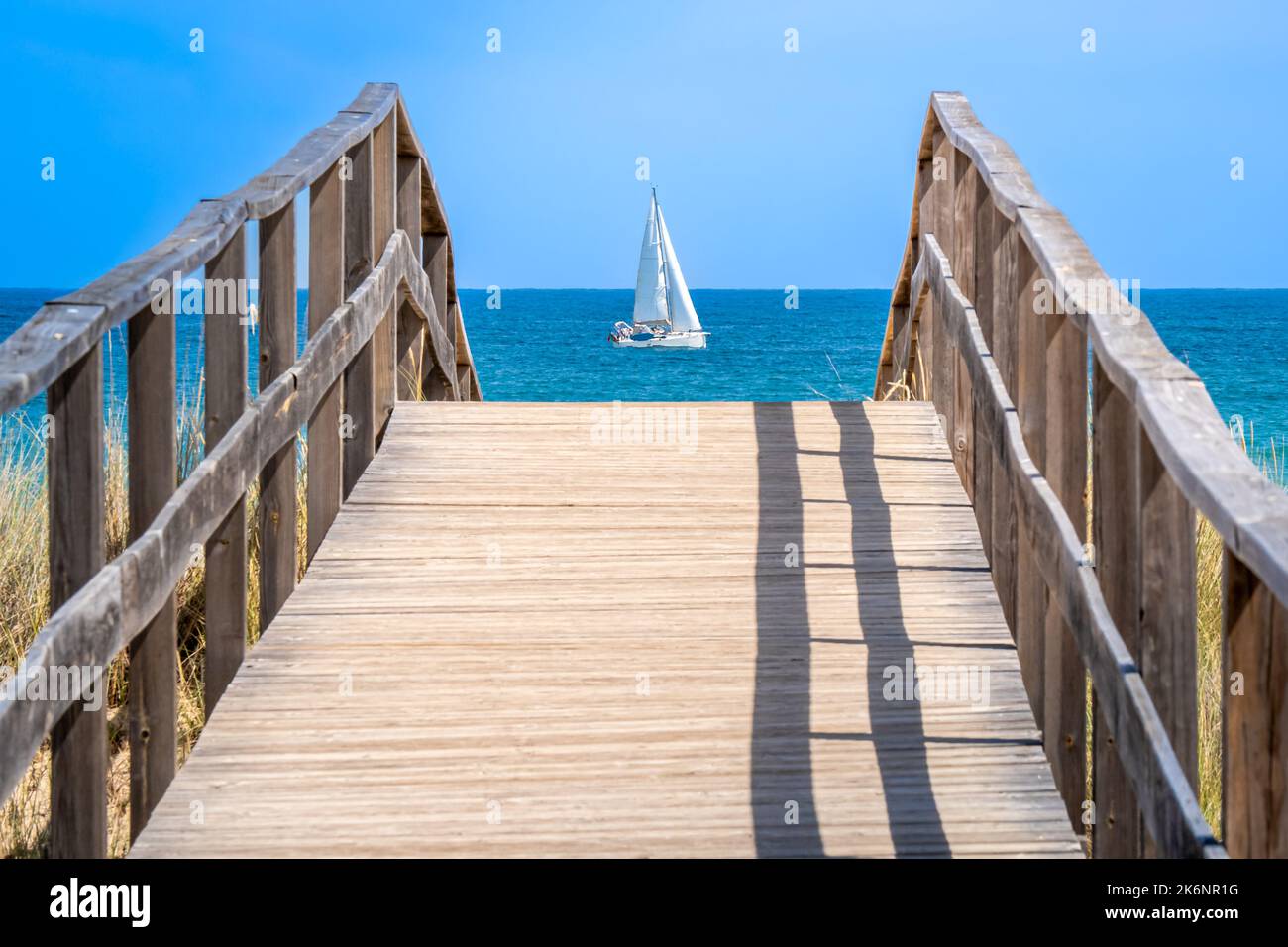 A wooden pedestrian bridge build over a sand dune gives access to the ...