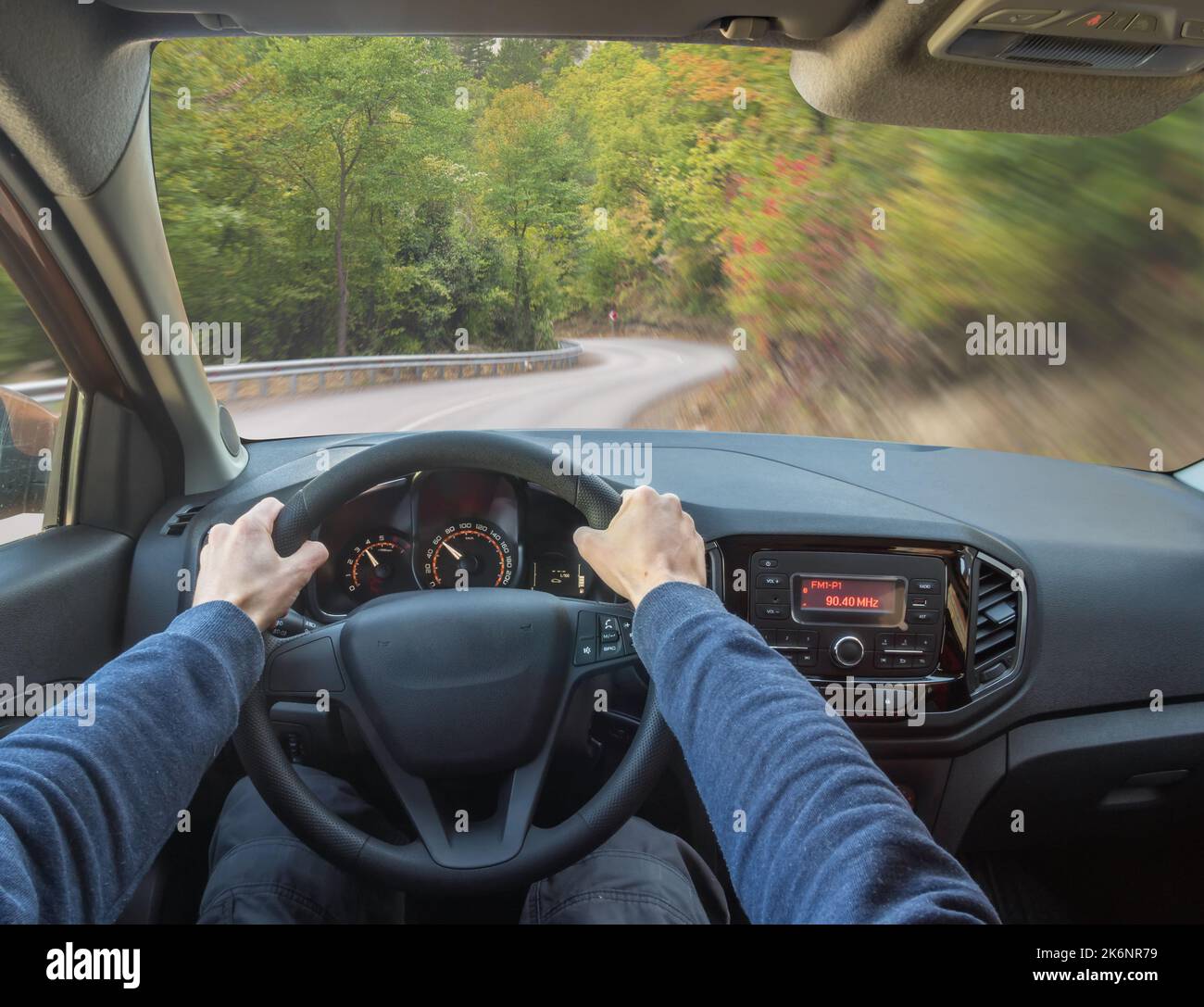 Man driver hands holding the car steering wheel. Fast speed and road in ...