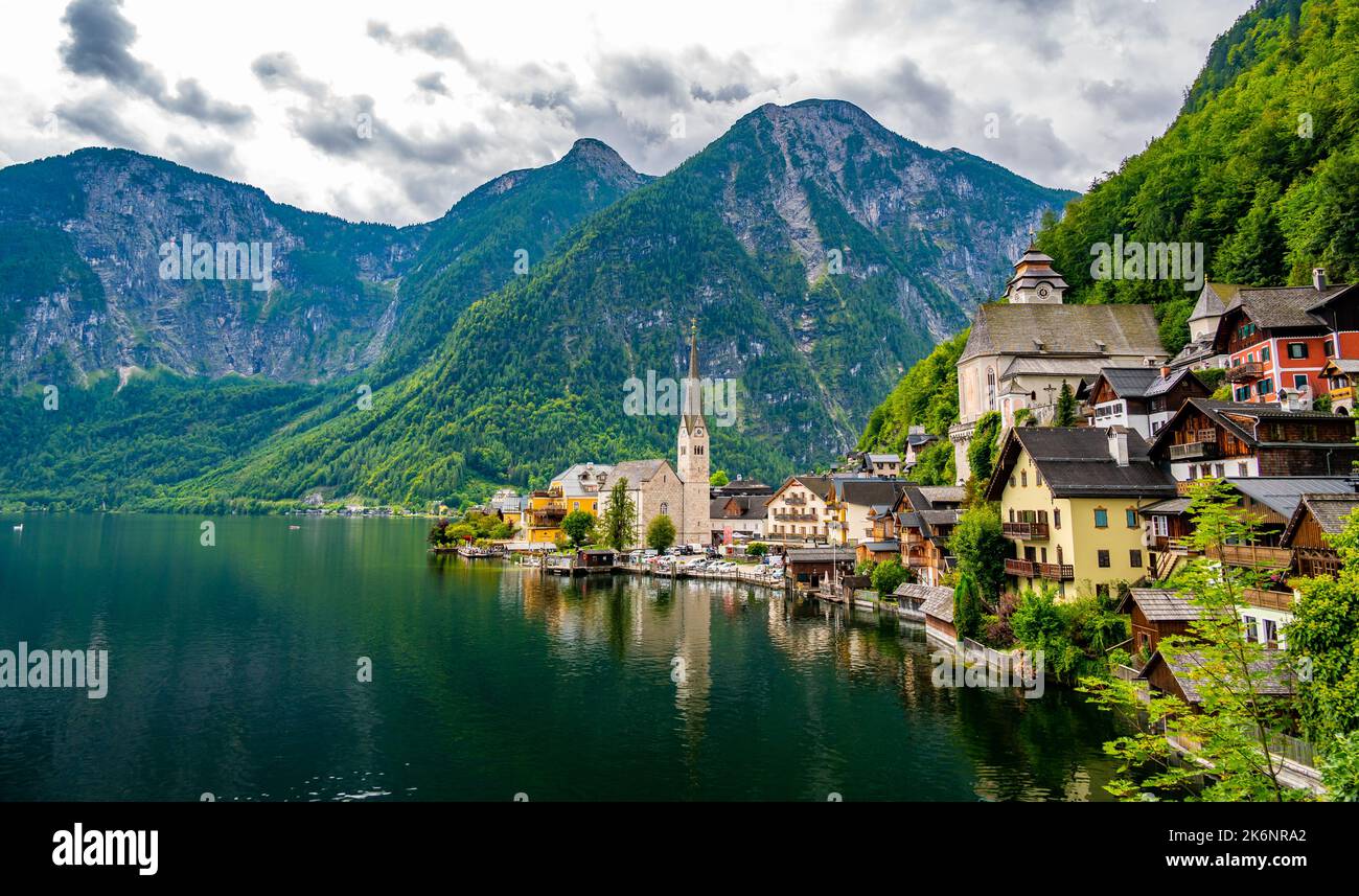 Famous view of Hallstatt city and church near the lake. Mountains in ...