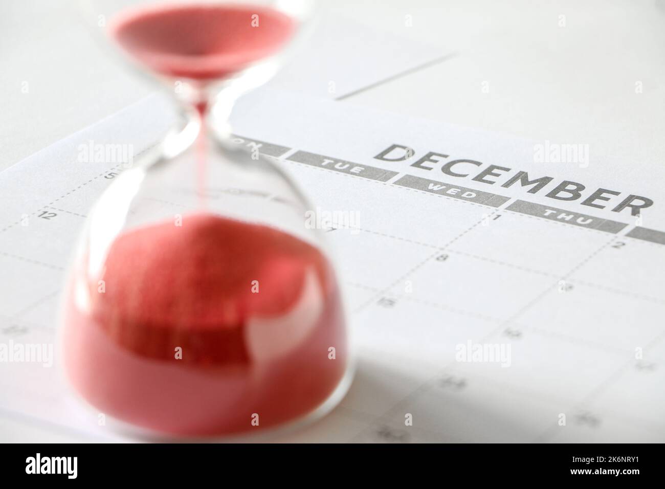 December calendar, with hourglass running out of time and out of focus ...