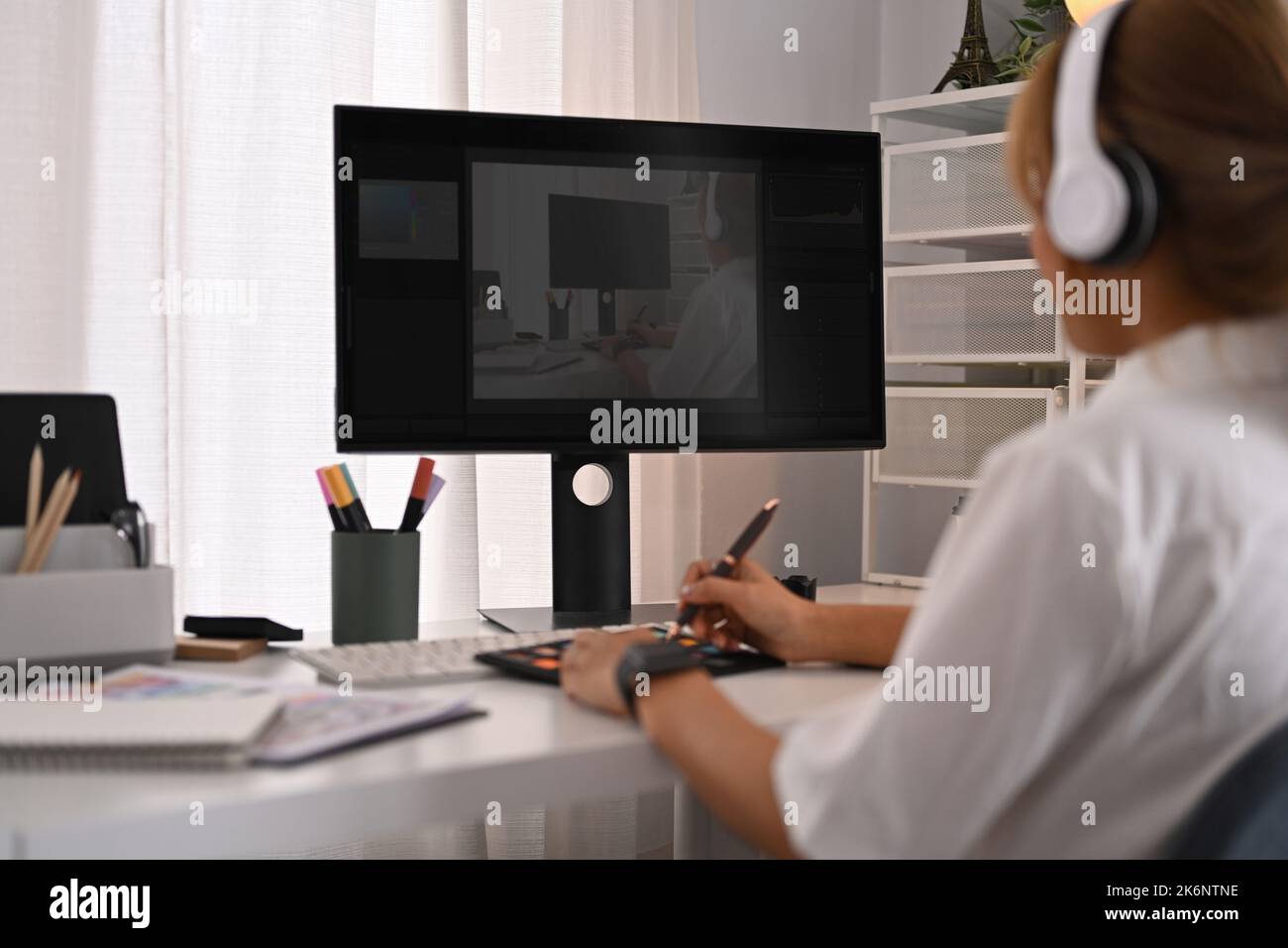 Rear view of young creative woman working with color swatches and ...