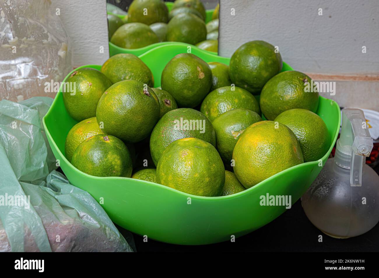 Orange fruits with peel in green color in a green container Stock Photo ...