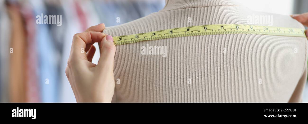 Seamstress with measuring tape measures on a mannequin Stock Photo - Alamy