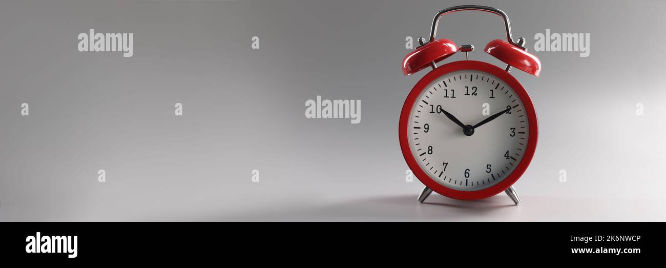 Close-up of a red alarm clock on a gray background Stock Photo - Alamy