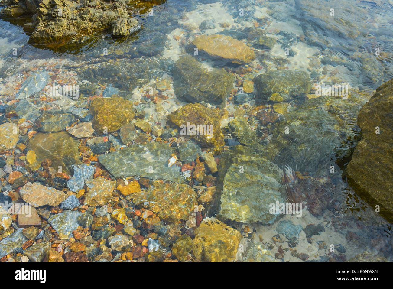 Crystal clear shallow sea water showing rocks underneath Stock Photo ...