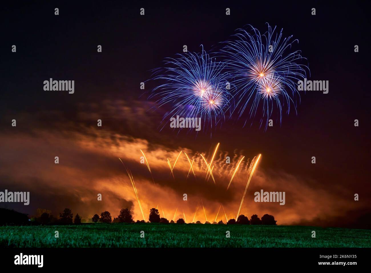 Fireworks with blue stars and yellow fountains against dark night sky ...