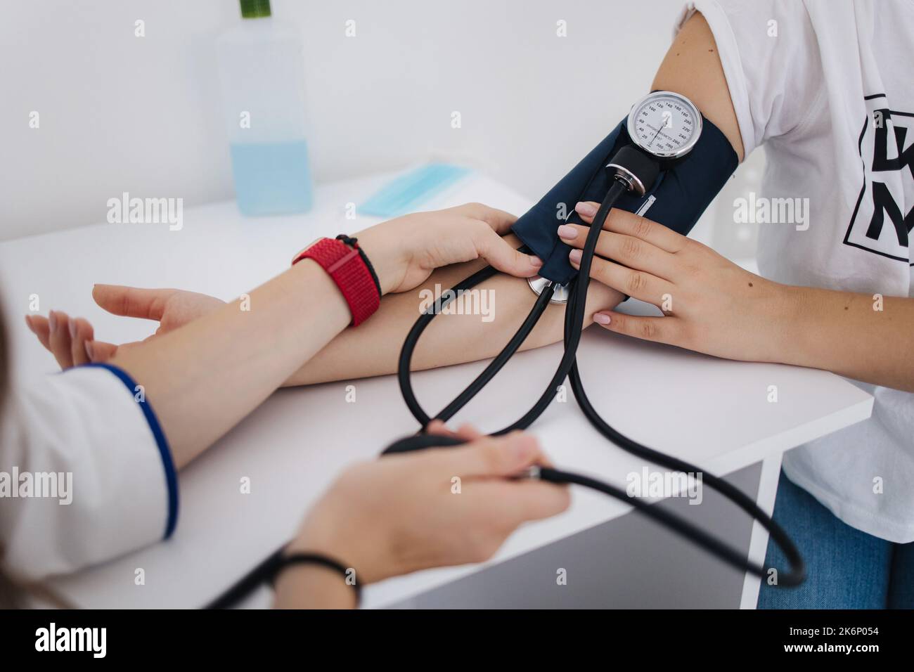 Close-up of doctor using sphygmomanometer with stethoscope checking ...