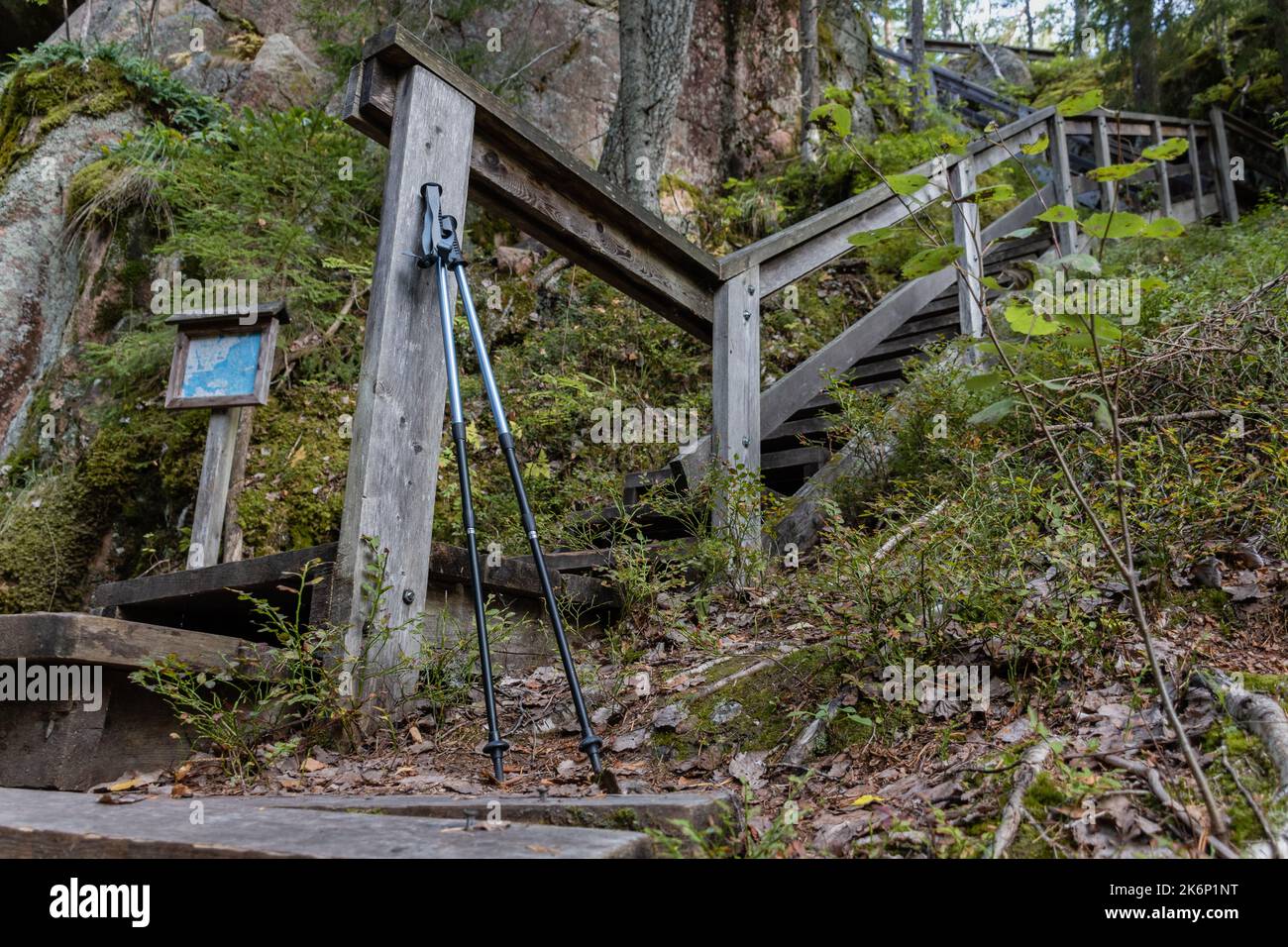 Hiking poles leaning on the handrail of a wooden stairs in a Finnish ...