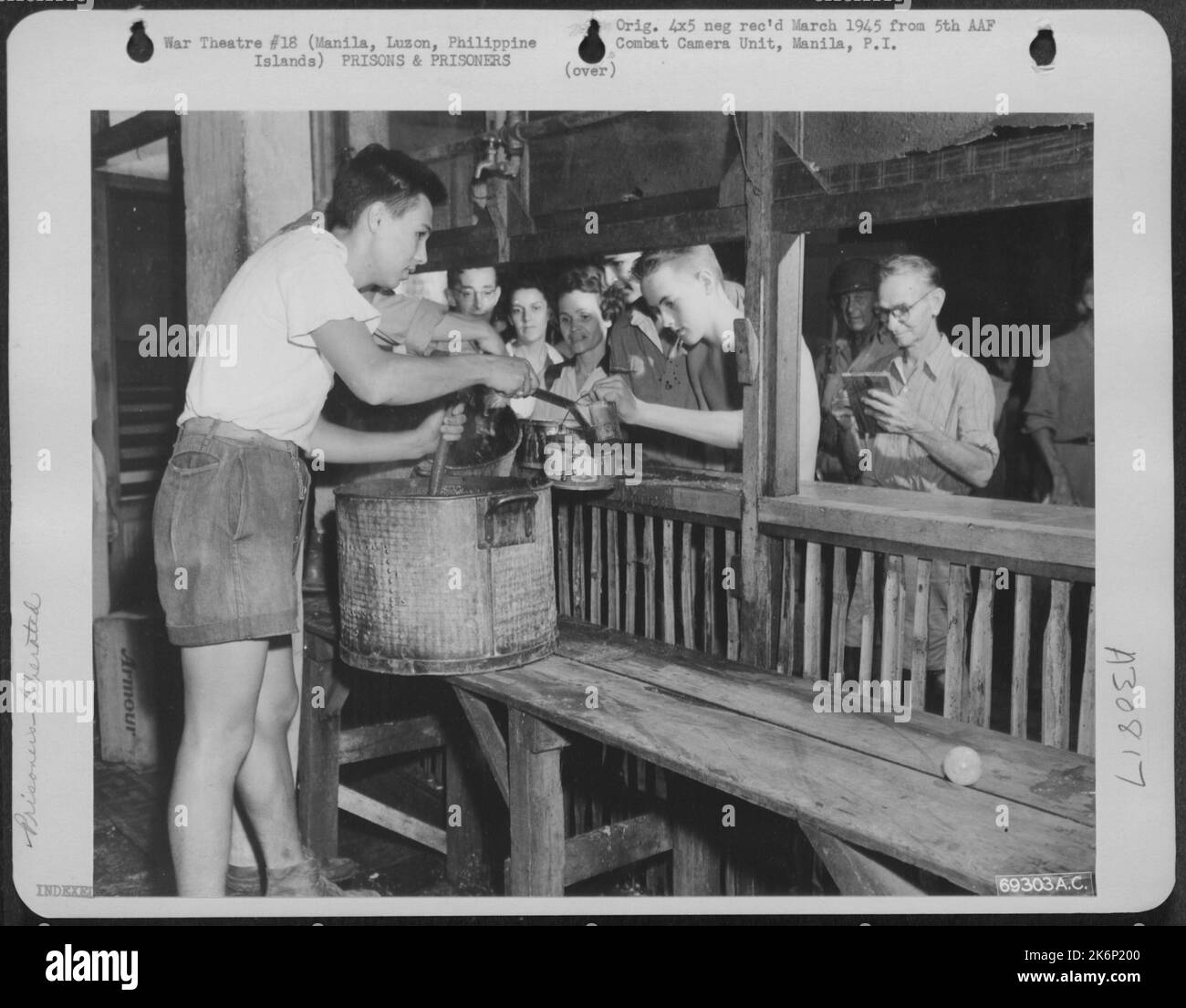 In the dreary basement of the Santo Tomas Prison, G.I.'s dole out food ...