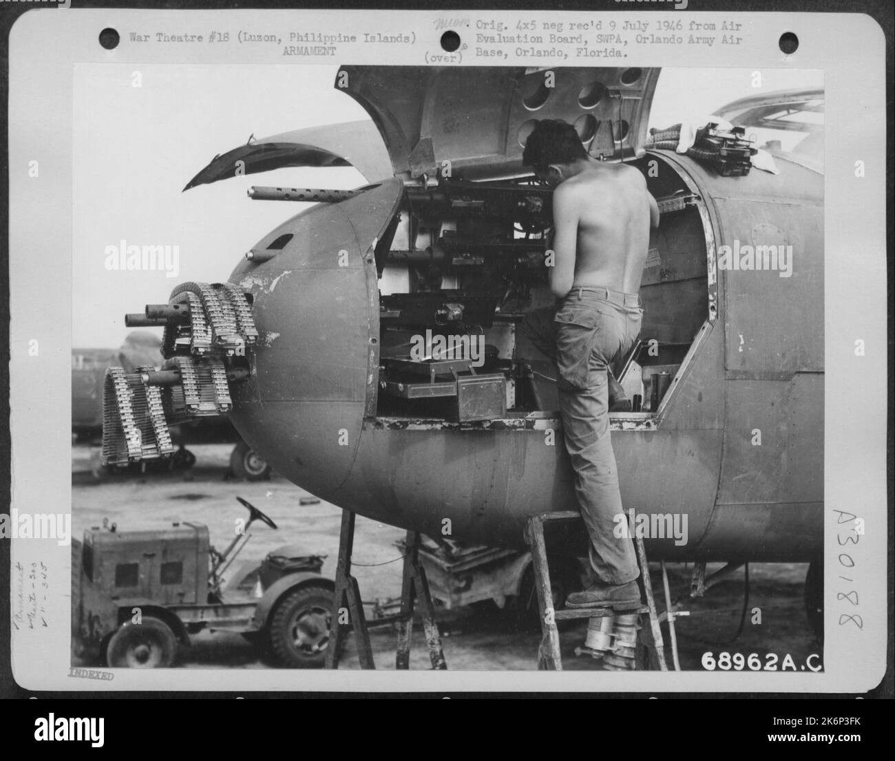An armorer cleans the 50 cal machine guns in the nose of a North ...